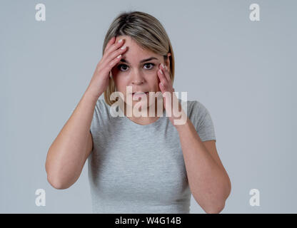 Portrait of a surprised confused woman in yellow casual calling mobile ...