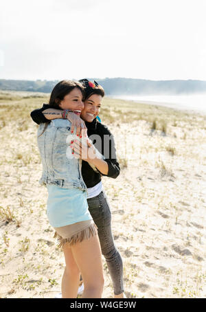 Happy friends hugging on the beach Stock Photo - Alamy