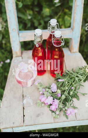 Bottled mallow juice and glass on a chair Stock Photo - Alamy