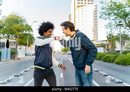 Fist bump greeting. Two people in suits greet each other in a meeting ...