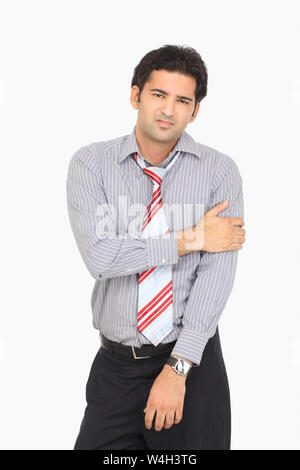 Indian businessman suffering from arm pain Stock Photo - Alamy