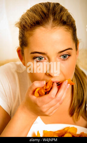 Woman watching television and eating snacks Stock Photo - Alamy