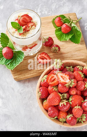 Strawberry granola or smoothie in glass and fresh berries in wooden ...