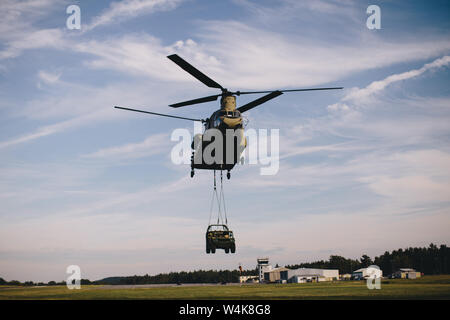 U.S. Army paratroopers sling load an M-119A2 105 mm howitzer to a UH ...