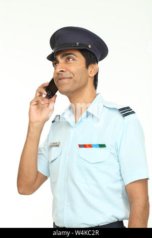 Middle aged pilot talking on landline phone, holding telephone, having ...