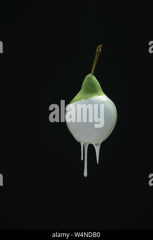Green Pear dripping white paint on a black background Stock Photo - Alamy