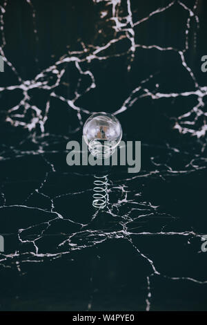 idea lightbulb popping up on spring with black marble background ...