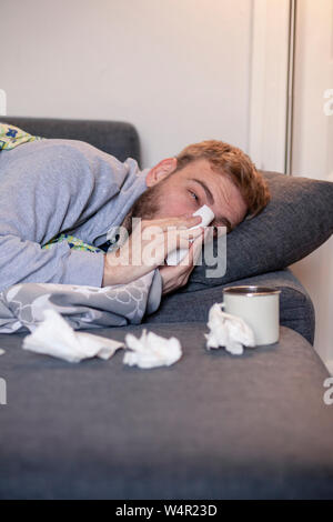 One young sick man feeling bad and pain on his neck muscle at home ...