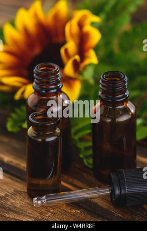 bottles with essential oils, dropper and sunflower on white background ...