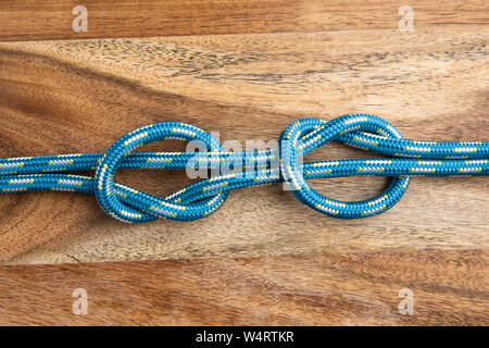 Fishing node on wooden background. Nautical rope knot Stock Photo - Alamy
