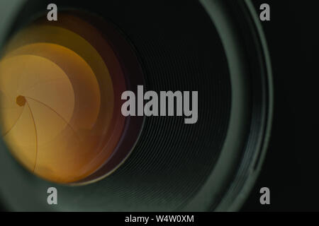 Close up camera aperture lens with yellow glass reflection. Macro view ...