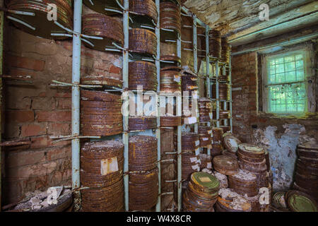 Destroyed from time to time storage room with stored old rusty round ...