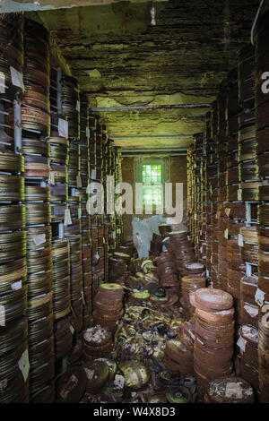 Destroyed from time to time storage room with stored old rusty round ...