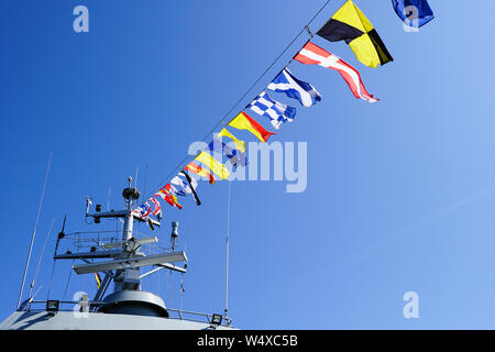 a gray warship fragment decorated with a row of colorful nautical ...