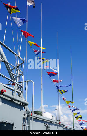 a gray warship fragment decorated with a row of colorful nautical ...