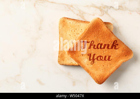 Toasted bread with inscription THANK YOU on light background Stock ...