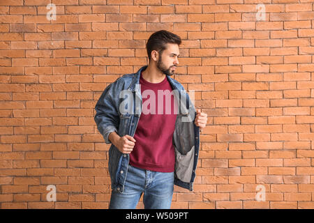 Fashionable young man near brick wall Stock Photo - Alamy