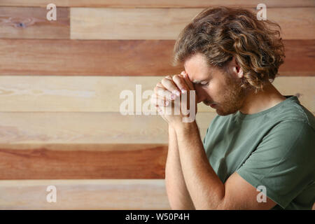 Religious young man praying on dark background Stock Photo - Alamy