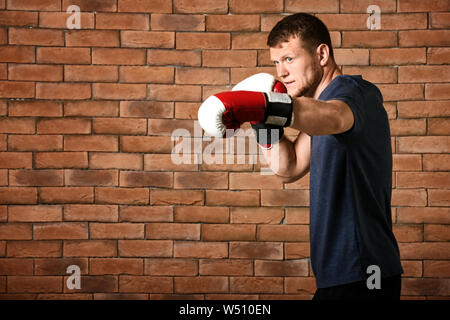 Strong male boxer against brick wall Stock Photo - Alamy