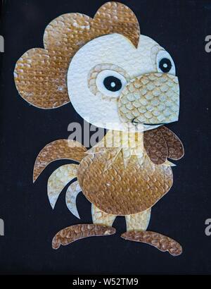 A painting made of fish skins by the Hezhen People is on display at a ...