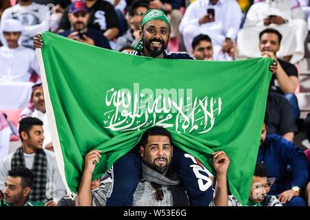 Saudi Arabian football fans hold up their national flags to show ...