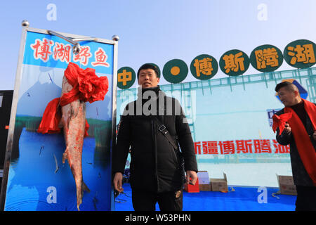 The owner poses with a 23-kilogram fish, which is the biggest catch ...