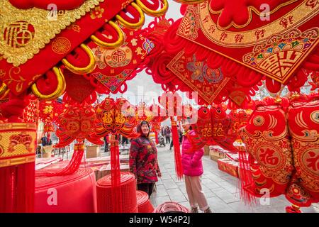 Residents shop for festive decorations at a commodity market in Huai'an ...