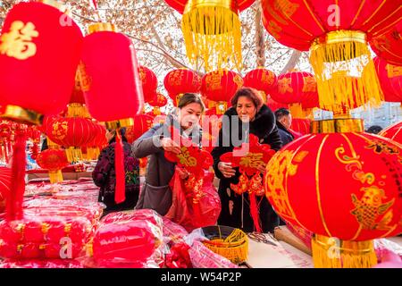 Residents shop for festive decorations at a commodity market in Huai'an ...