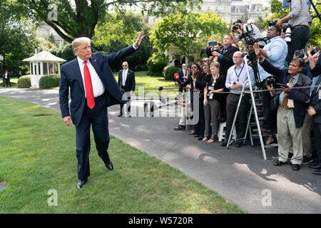 President Donald Trump waving to the press after returning to the White ...