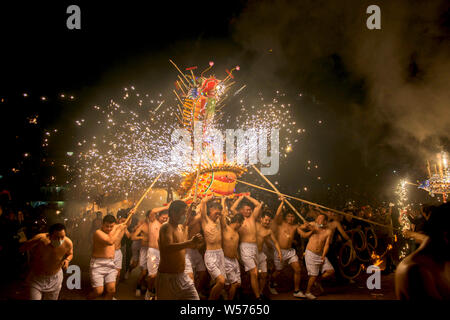 Chinese entertainers perform a fire dragon dance to celebrate the ...
