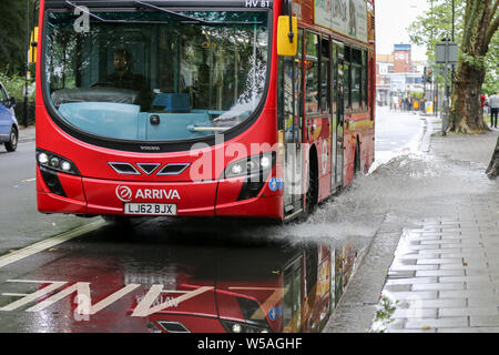 A bus drives through water on a flooded road Stock Photo - Alamy