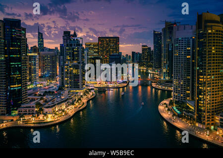 The skyline of Dubai Marina after sunset with a sea in the foreground ...