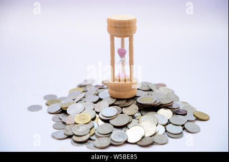 Deadline and time is money concept with hourglass and US coins currency ...