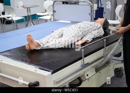 Patient dummy lying on mobile hospital bed while medic adjusting Stock ...