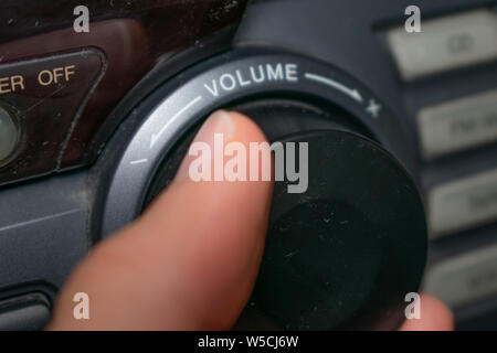 A person turning the volume wheel up or down (the focus is on the word ...