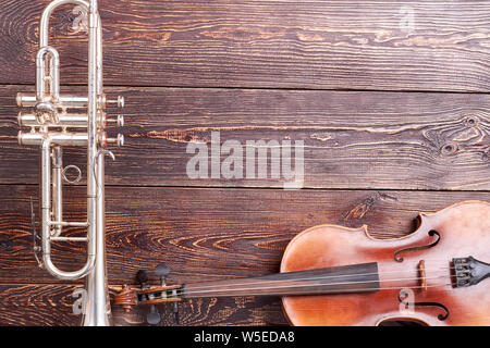 Aged violin and trumpet on wooden background. Old musical instruments ...