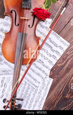 Beautiful red rose and musical notes on piano keys, closeup. Space for ...
