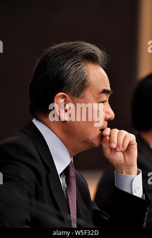 Chinese Foreign Minister Wang Yi (center) waves as he leaves a press ...