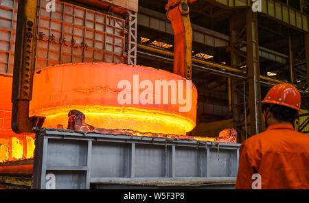 --FILE--Chinese workers check a seamless forging piece at a forging ...