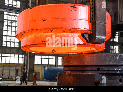 --FILE--Chinese workers check a seamless forging piece at a forging ...