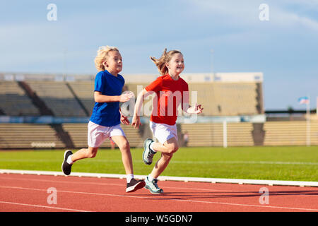 Child running in stadium. Kids run on outdoor track. Healthy sport ...
