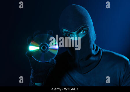 Hacker holding a pirated compact disc Stock Photo - Alamy