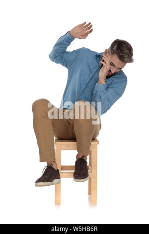 scared young casual man defending himself with his briefcase , isolated ...
