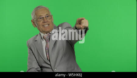 Elderly businessman points at something. Old man in formal wear showing ...