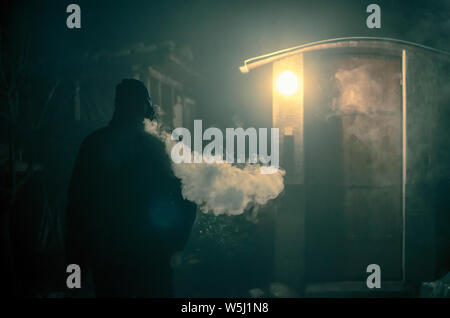 strange man smoking at night with big steam effect from the cigarette ...