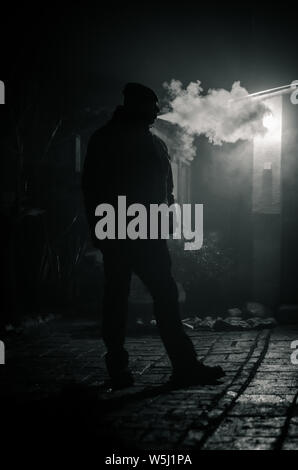 strange man smoking at night with big steam effect from the cigarette ...