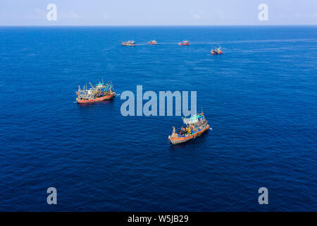 Overfishing - aerial view of a large fleet of fishing trawlers working ...
