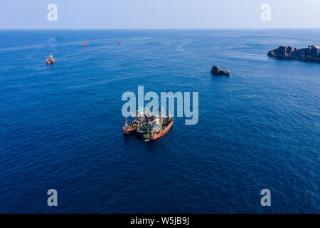Overfishing - aerial view of a large fleet of fishing trawlers working ...