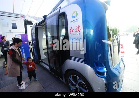 A FAW Hongqi or Red Flag unmanned 5G minibus is parked during an expo ...