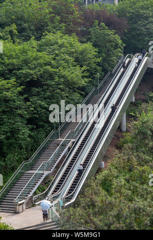 Local residents take the newly-built escalators to reach the top of a ...